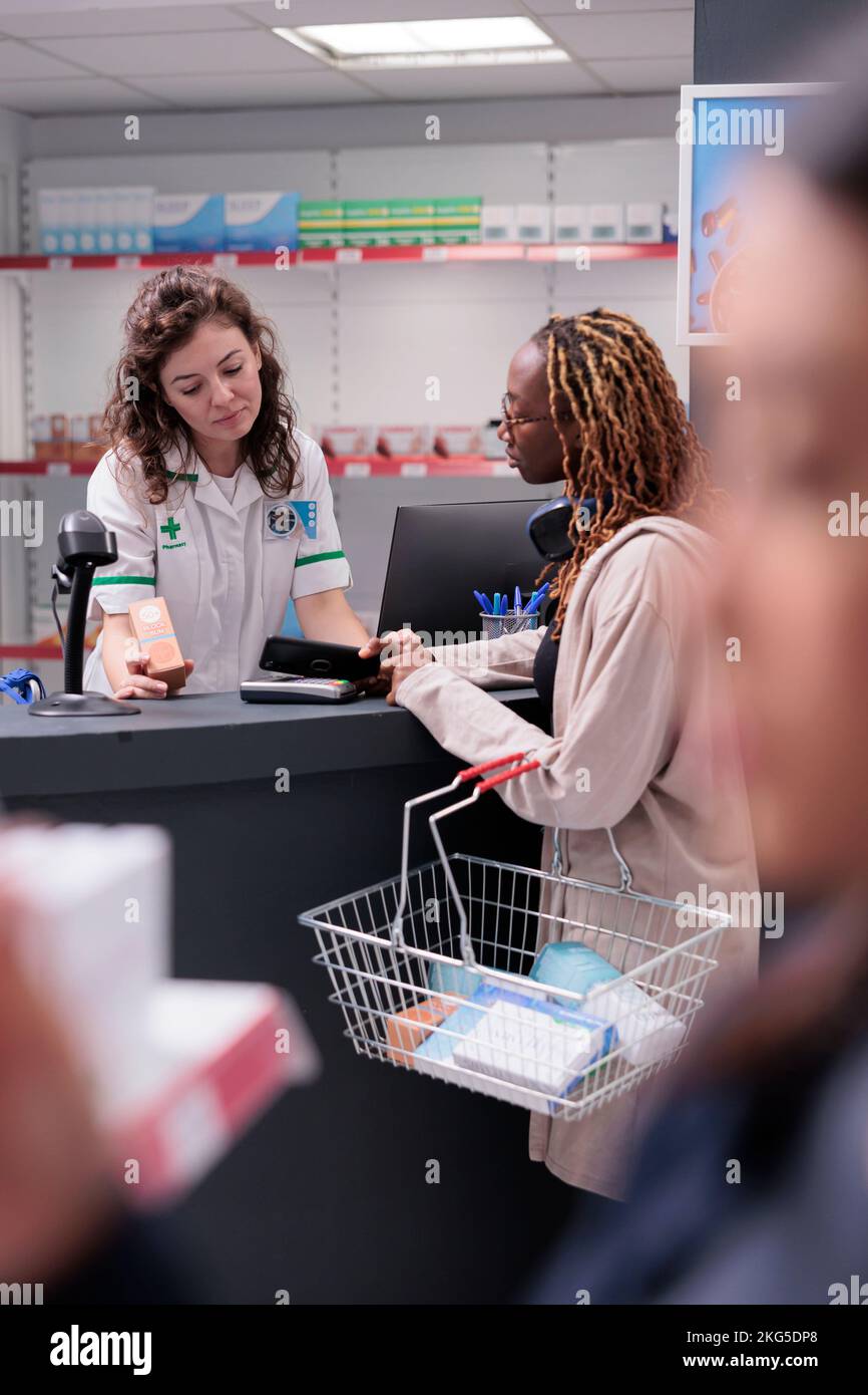 Cheerful customer buying pharmaceutical treatment, doing contactless ...