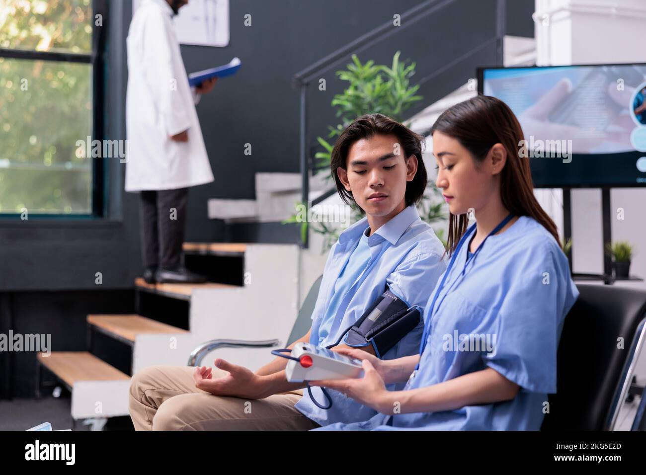 Nurse doing cardiology exam with instrument to measure hypertension and ...
