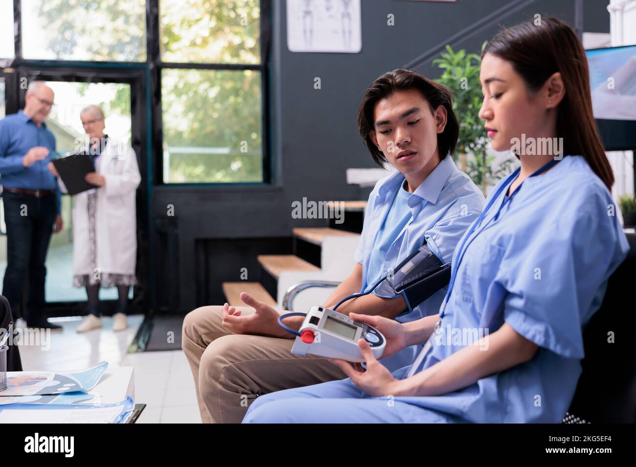 Cardiologist nurse measuring asian patient blood pressure and ...