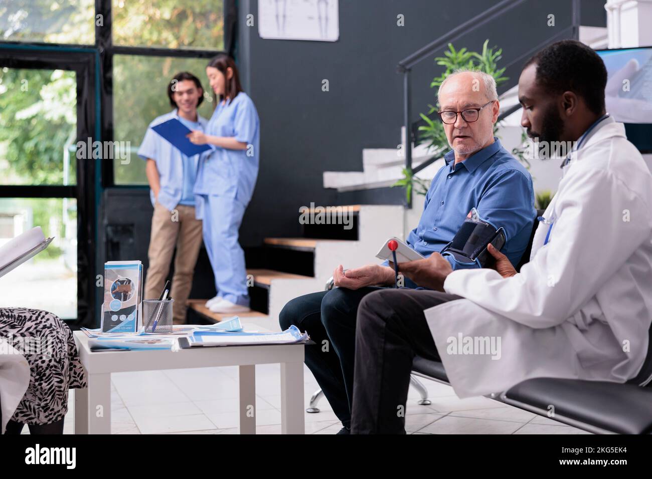 Physician measuring old patient blood pressure and hypertension with ...