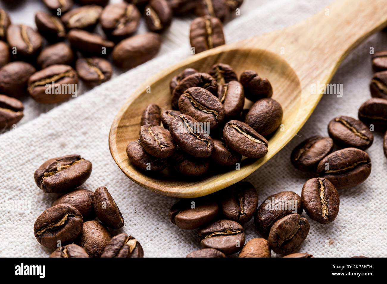 Roasted coffee beans with wooden spoon, closeup image, space for text ...
