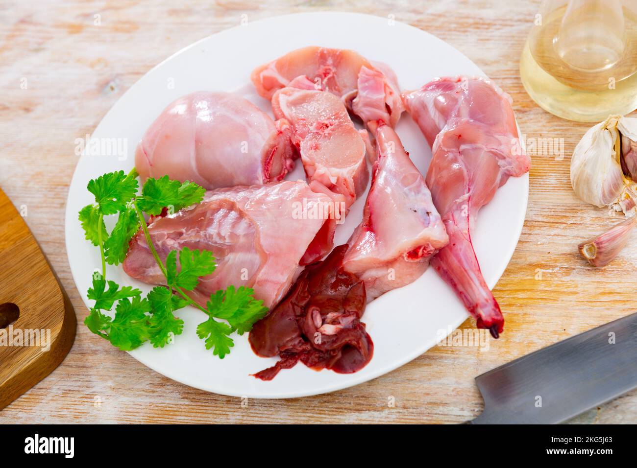 Chopped rabbit with garlic and spices on white plate with knife Stock ...