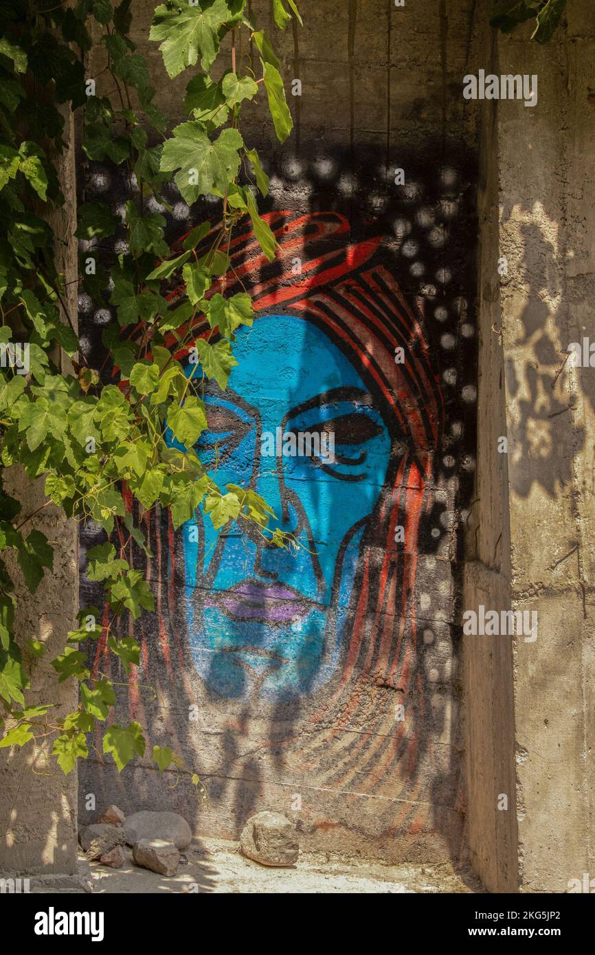 7-19-2019 Tbilisi Georgia Old mural painted on rough wall partly hidden ...