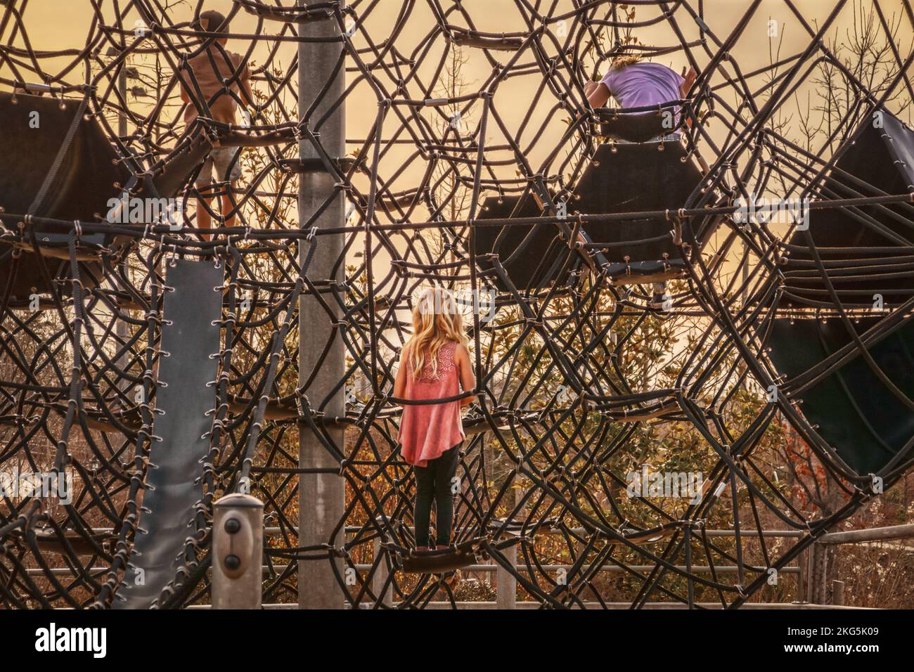 Children playing on climbing ropes at outdoor play park with focus on ...