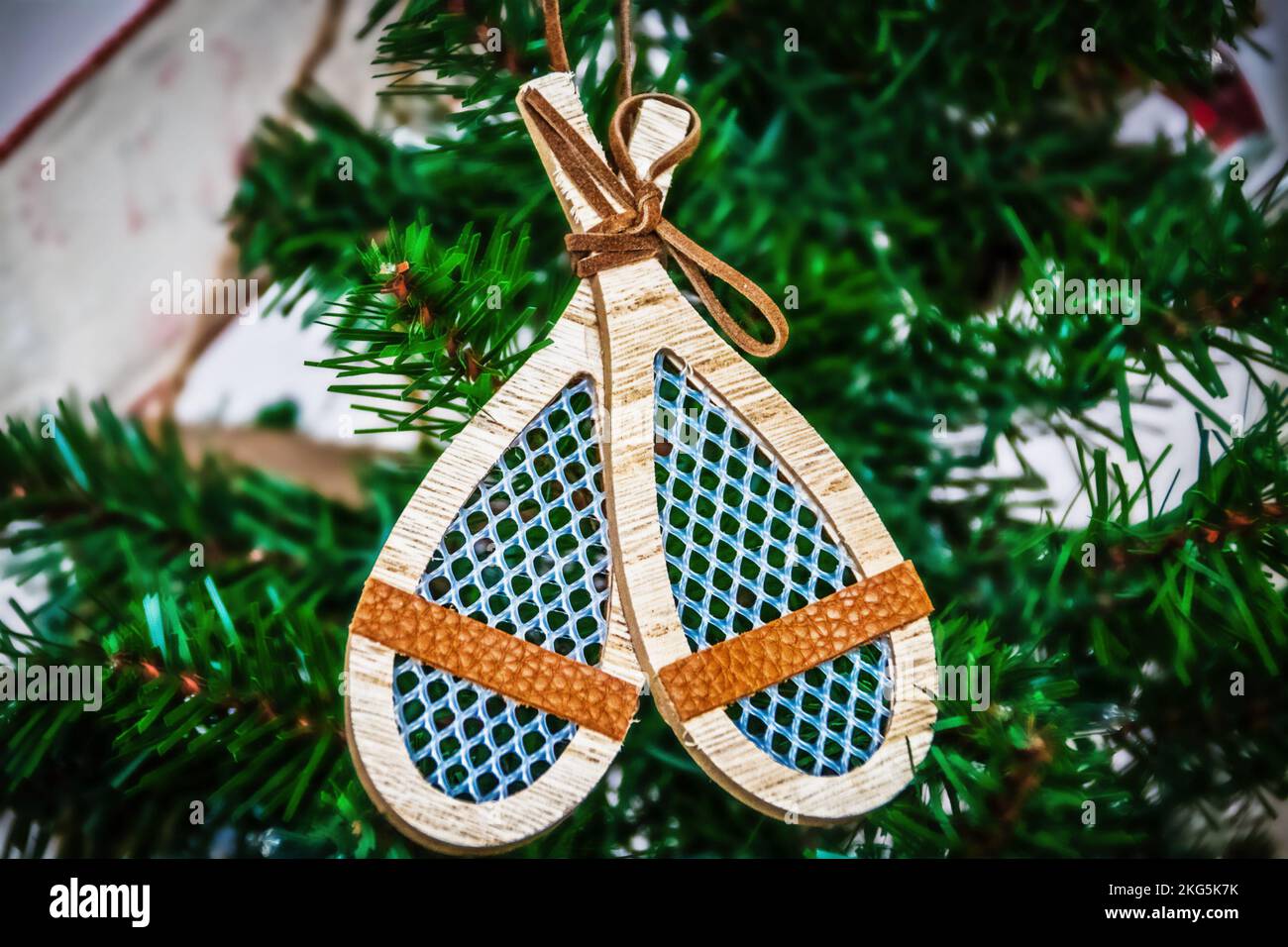 Snow shoe Christmas tree ornament hanging with leather thong to blurred ...