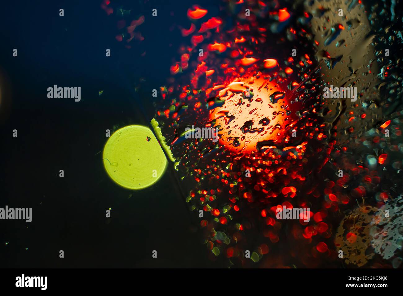 Closeup abstract city scene through window covered with heavy rain ...