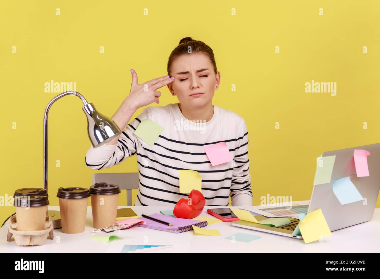 Depressed woman covered with sticky notes working on laptop, pointing ...