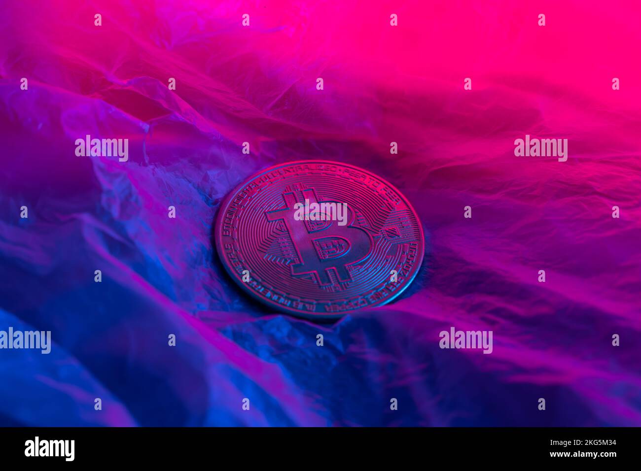 Bitcoin coin under neon on textured surface. Photo for presentation and ...