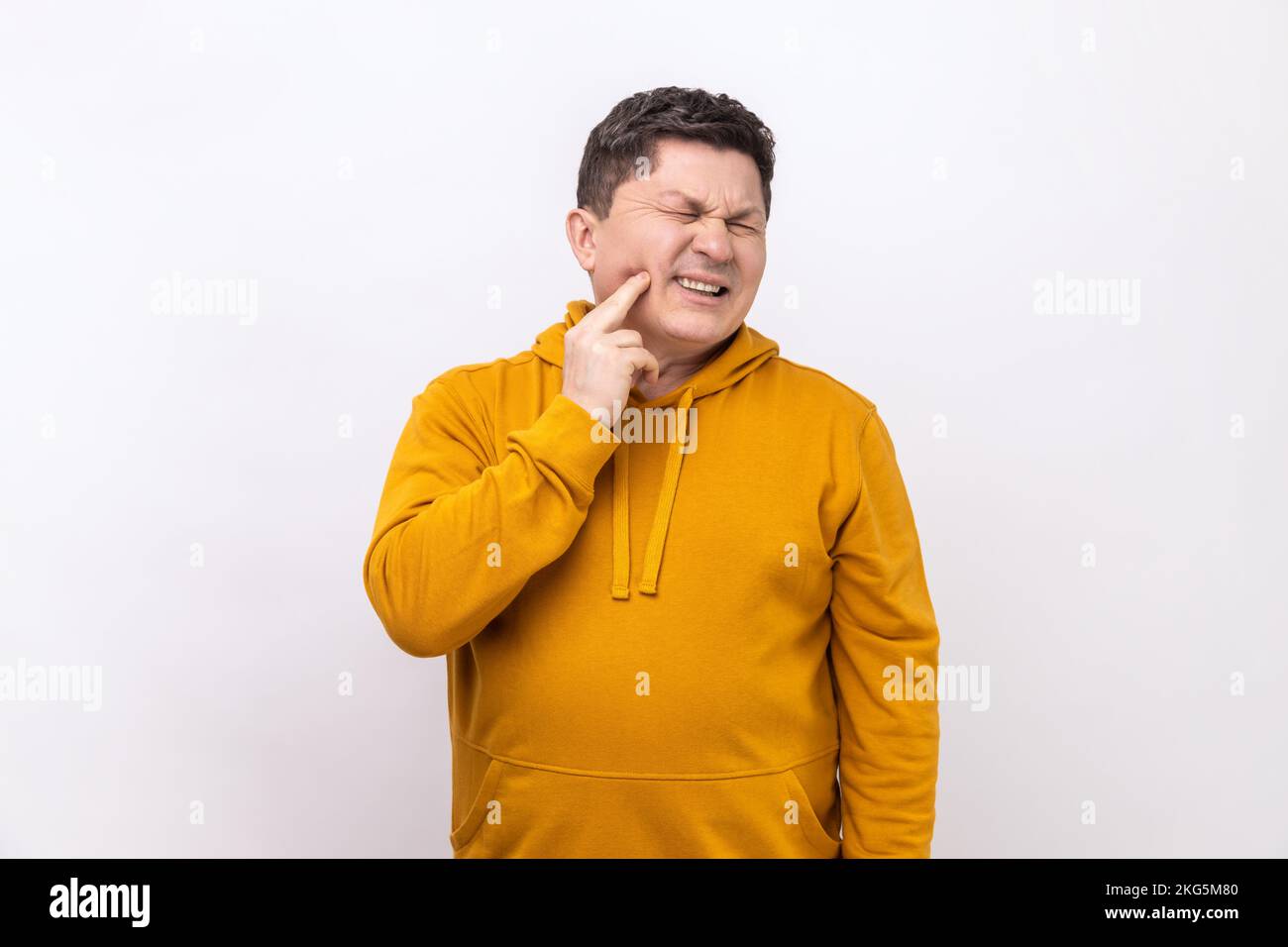 Unhealthy middle aged man wincing in pain and touching sore cheek ...