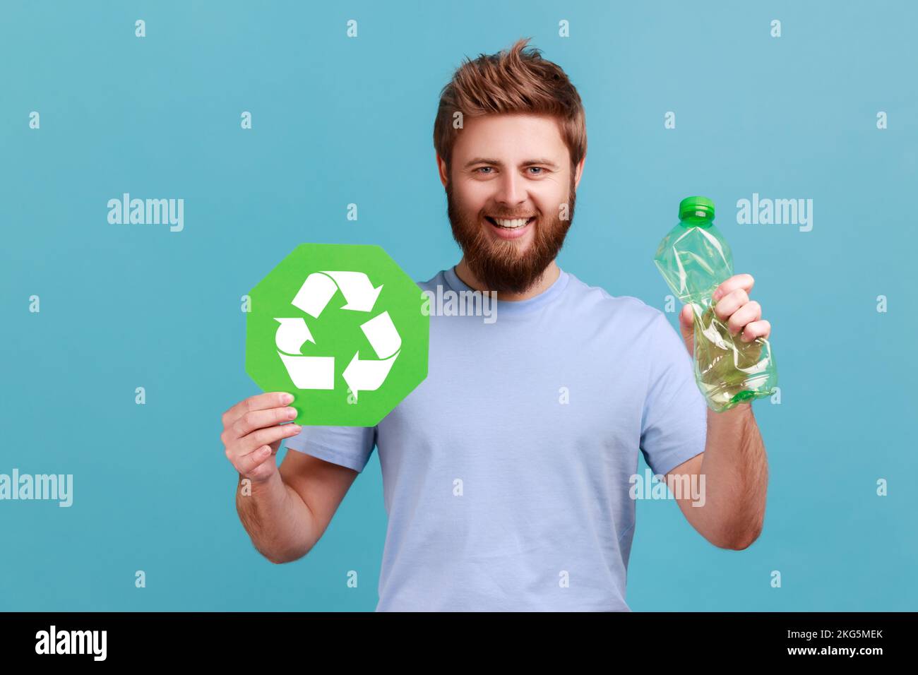 Portrait of smiling optimistic handsome bearded man pressing bottle ...