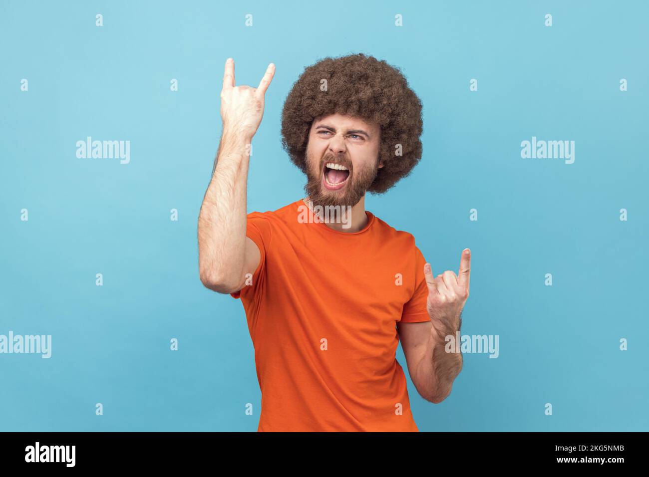 Portrait of funny crazy man with Afro hairstyle wearing orange T-shirt ...
