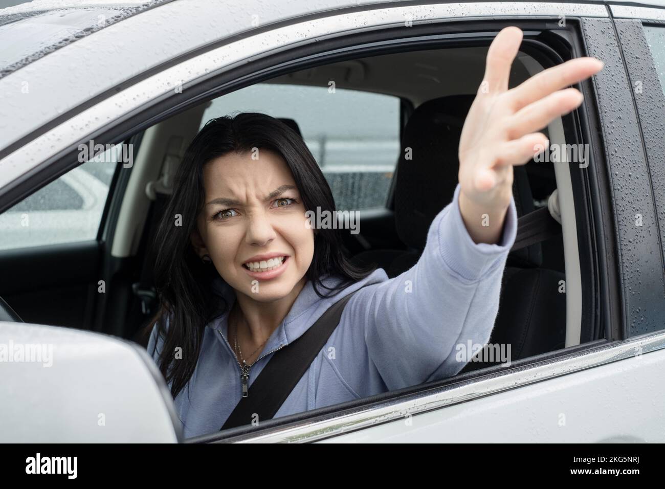 talking driver inside a car. Portrait of an aggressive young woman ...