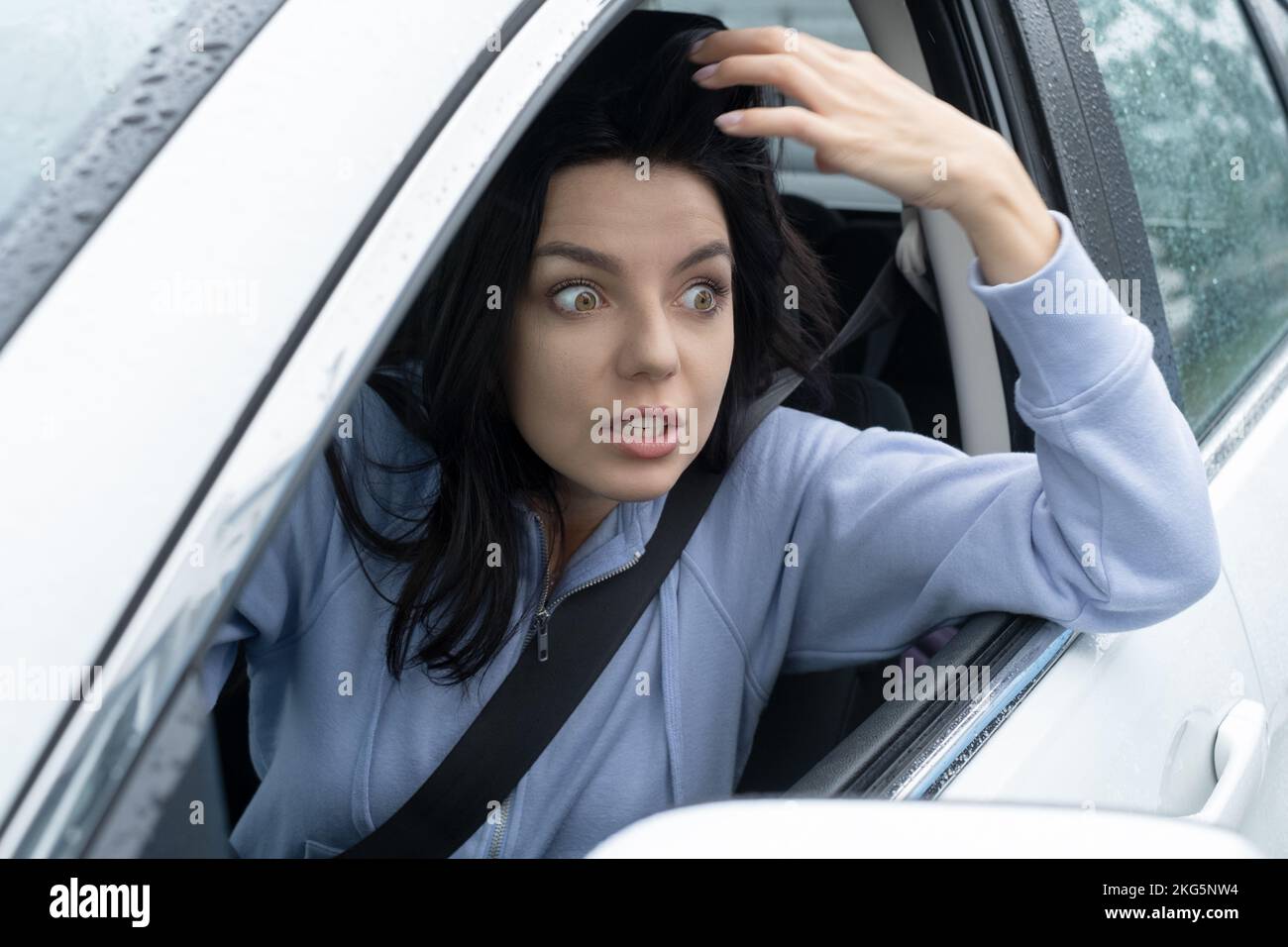Portrait of a Shocked and scared young woman driver driving a car ...