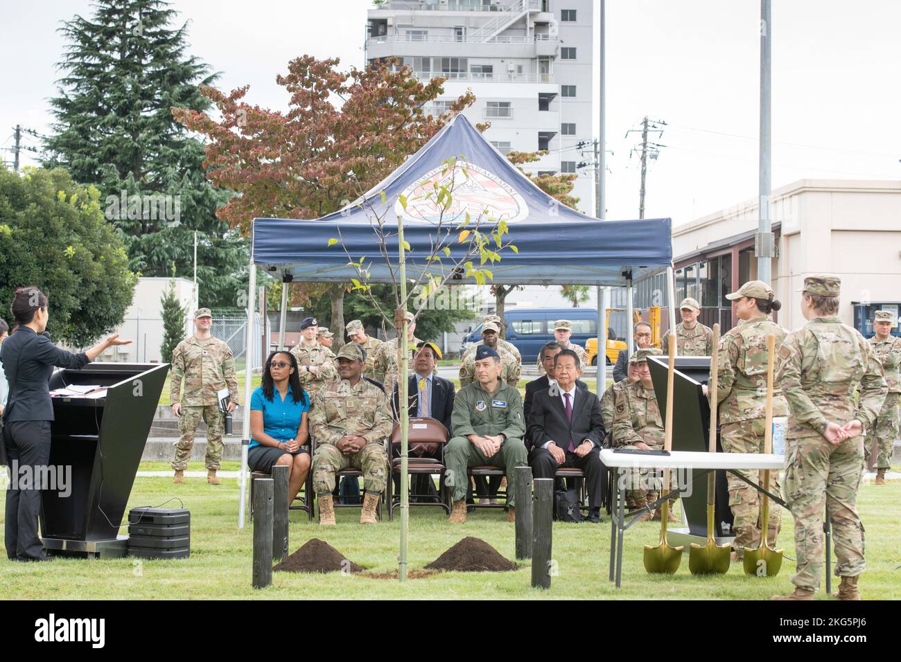 Attendees of a tree planting ceremony listen to the event’s emcees at ...
