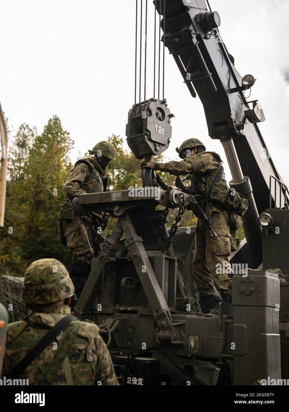 Soldiers with the Japan Ground Self Defense Force attach a tow bar to a ...