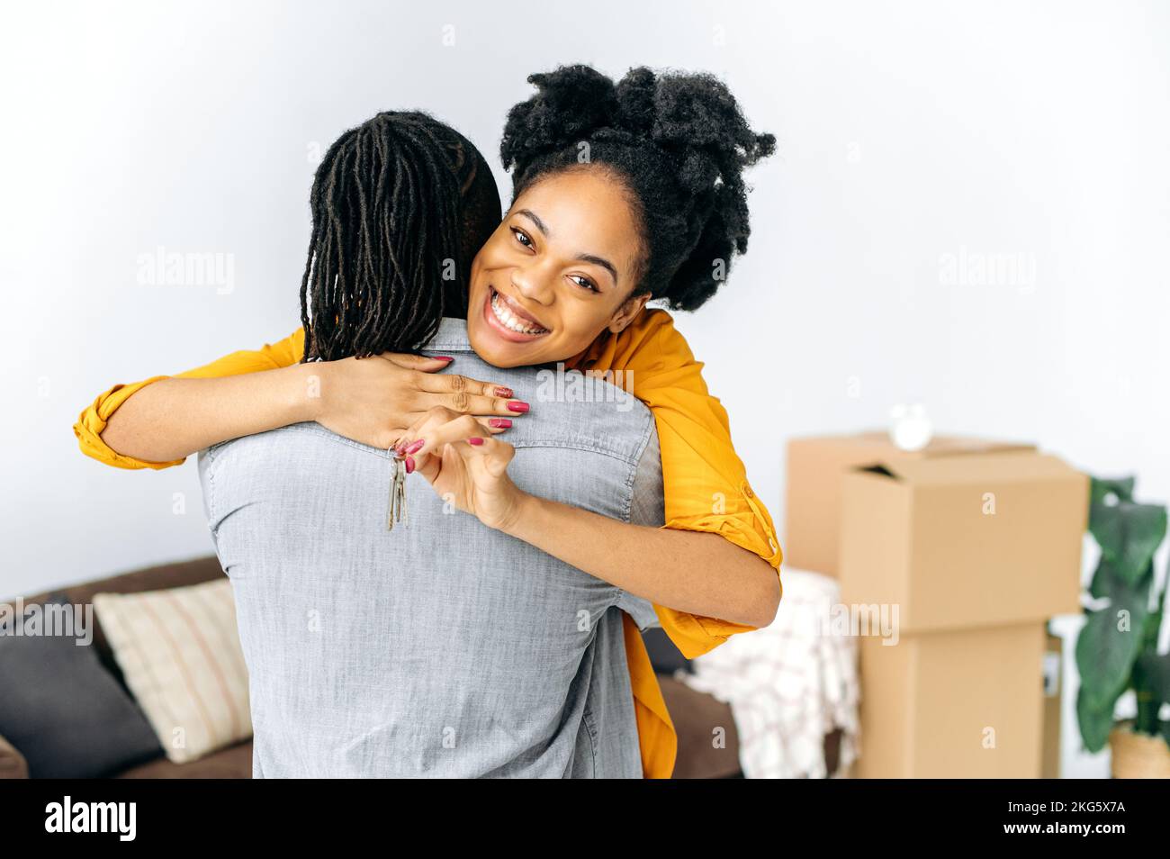 Excited joyful african american woman with dreadlocks, hugging her ...