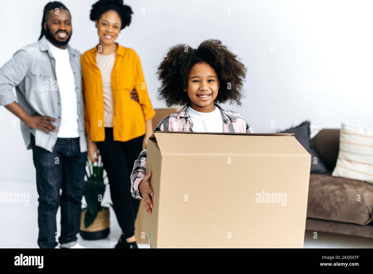 Happy family moving to a new house. Cute happy small African American ...