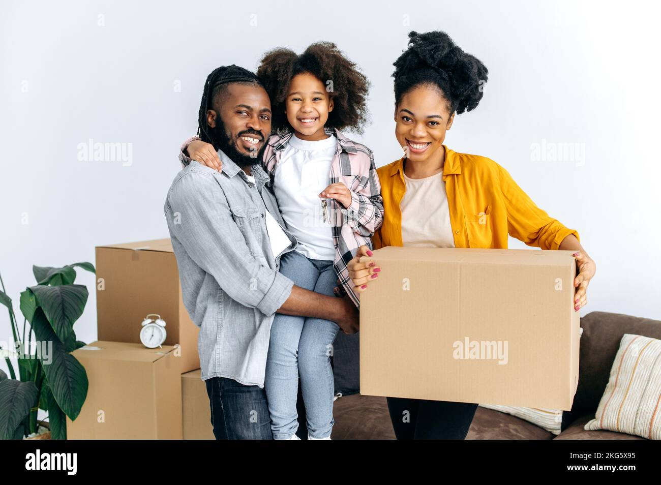 Happy african american family, dad mom and their cute daughter, moved ...