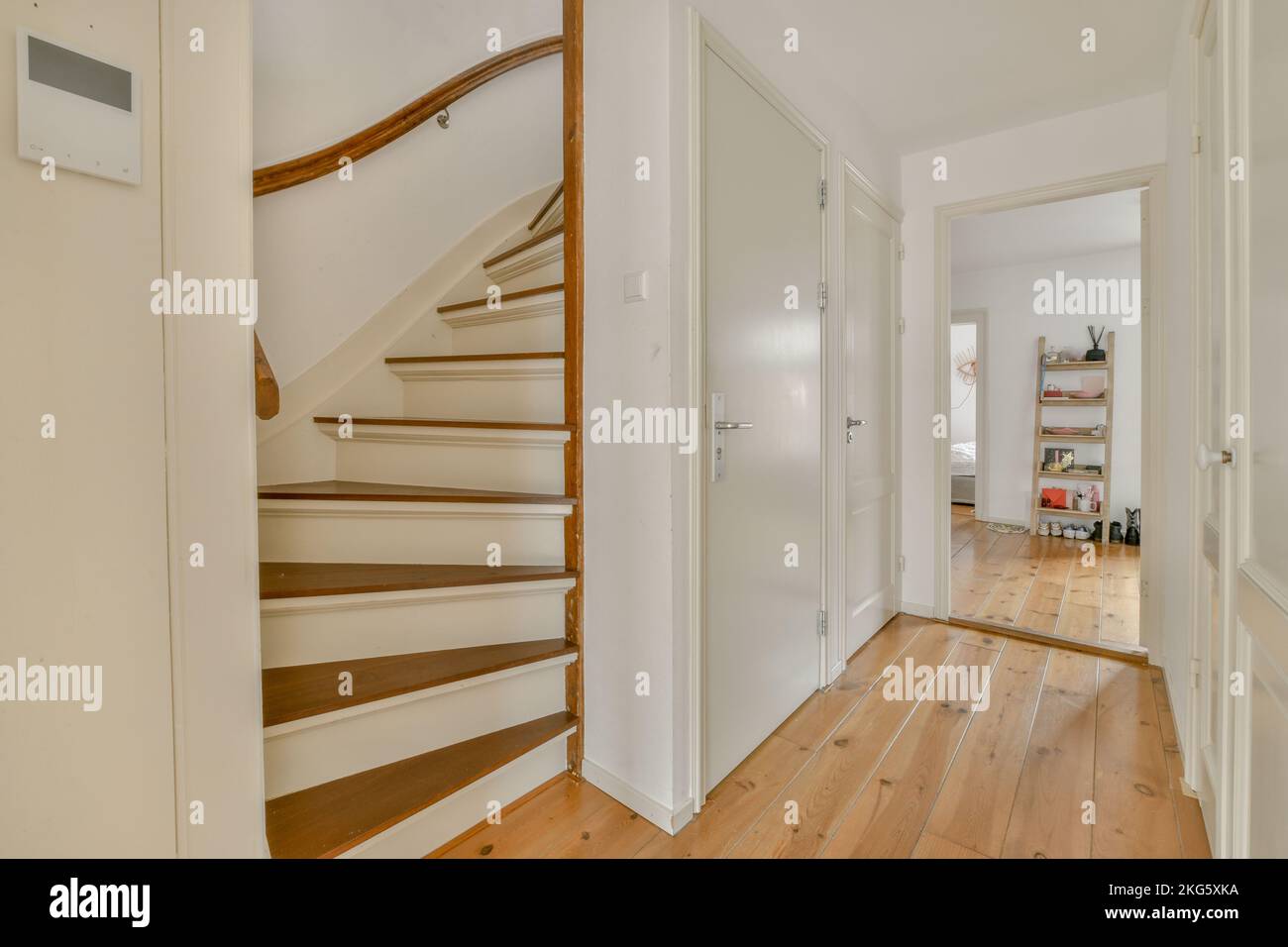 Light hallway with entrance door in two level apartment with minimalist ...