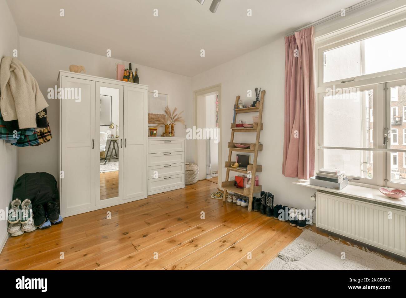 Wardrobe and shelf with decorations against window in light room Stock ...