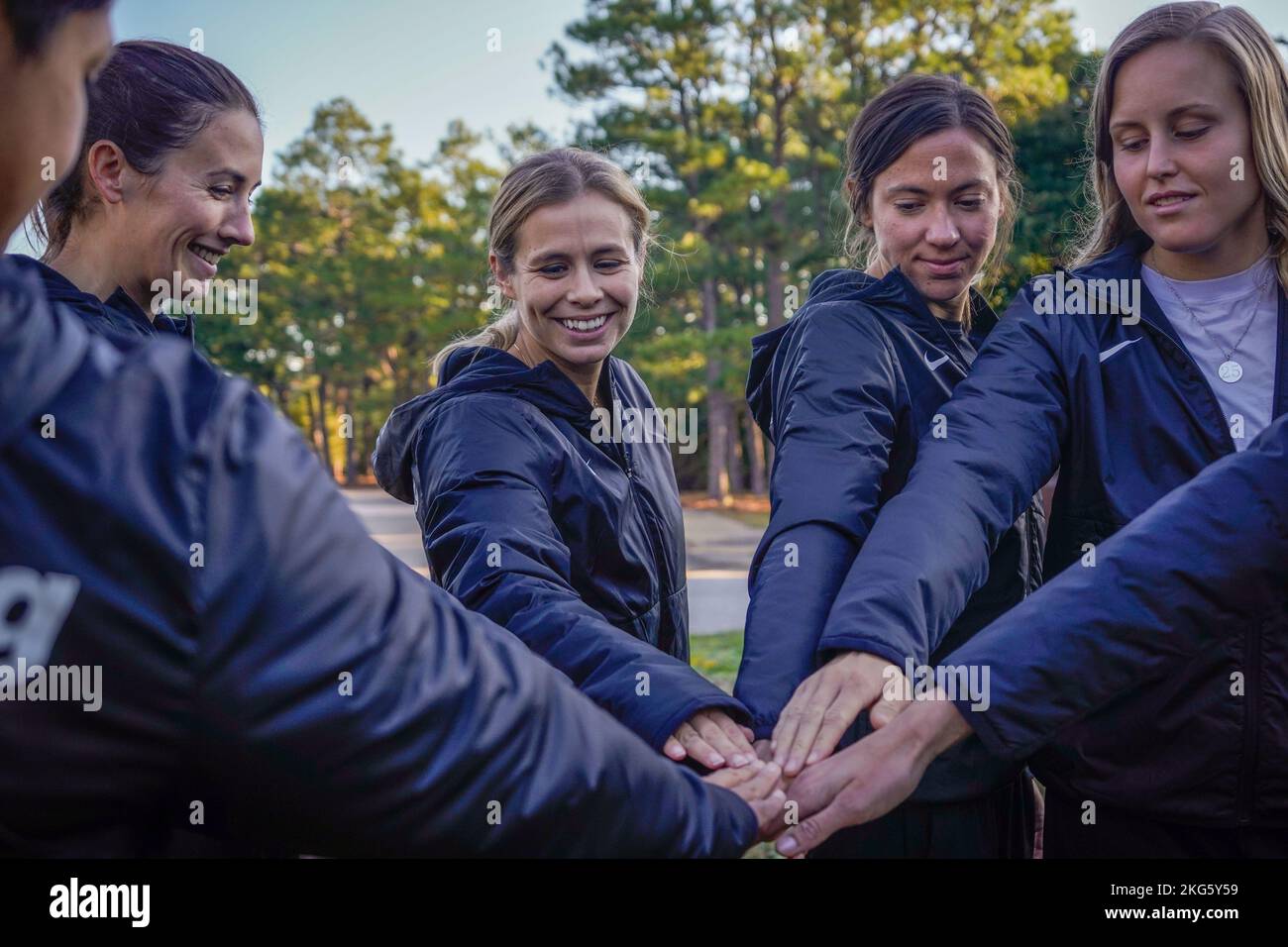 The Fort Bragg women’s team join their hands in the middle celebrating ...