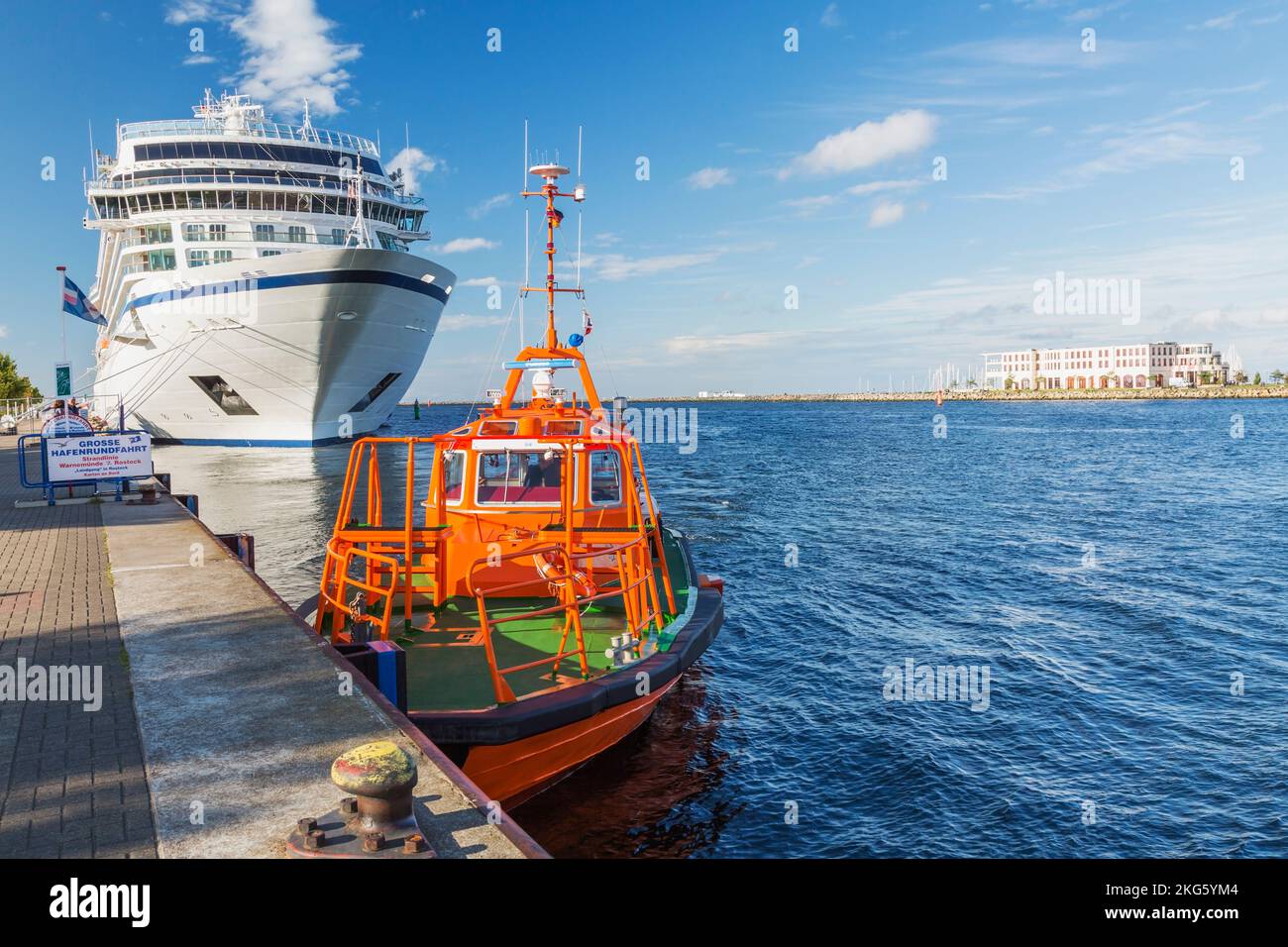 Orange tugboat and white and blue cruise ship moored at dock, Port of ...
