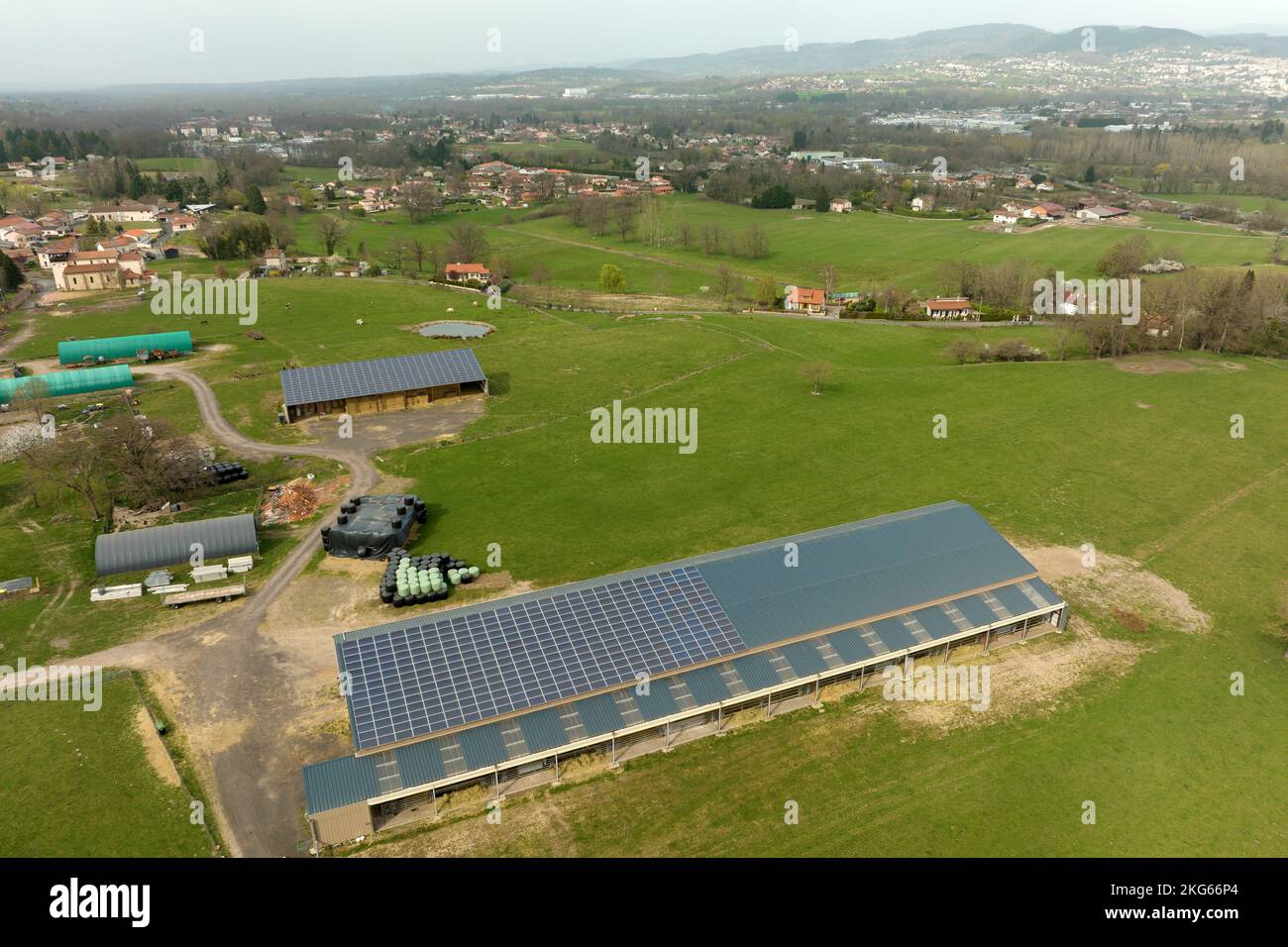Aerial view of blue photovoltaic solar panels mounted on farm building ...