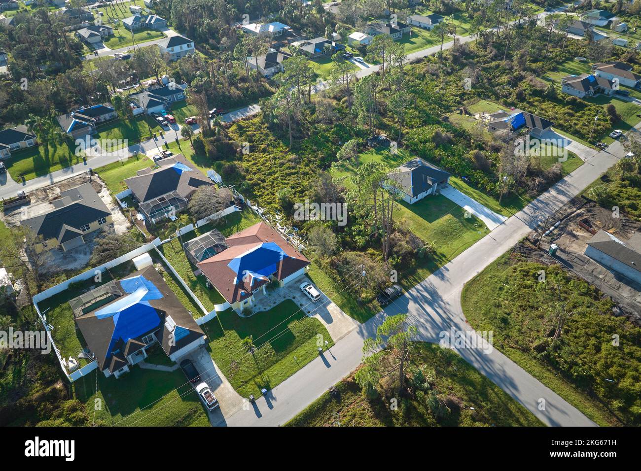 Aerial view of damaged in hurricane Ian house roof covered with blue ...