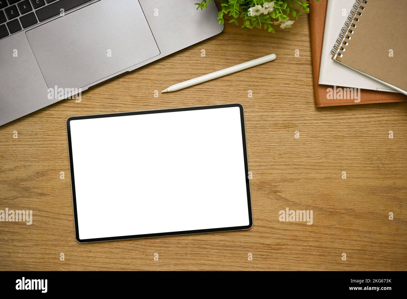 Digital tablet touchpad white screen mockup is on wooden tabletop ...