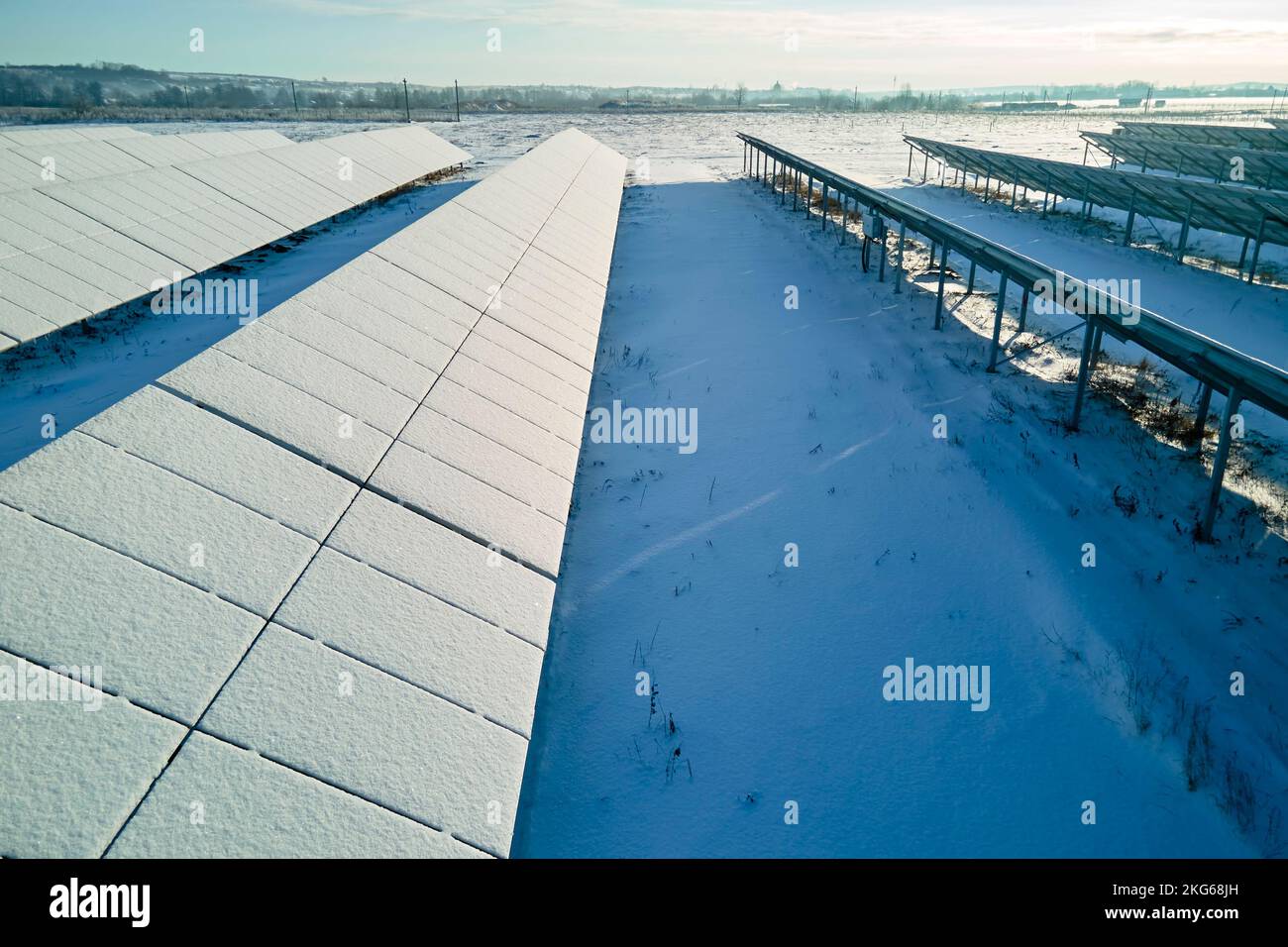 Aerial view of snow covered sustainable electric power plant with rows ...