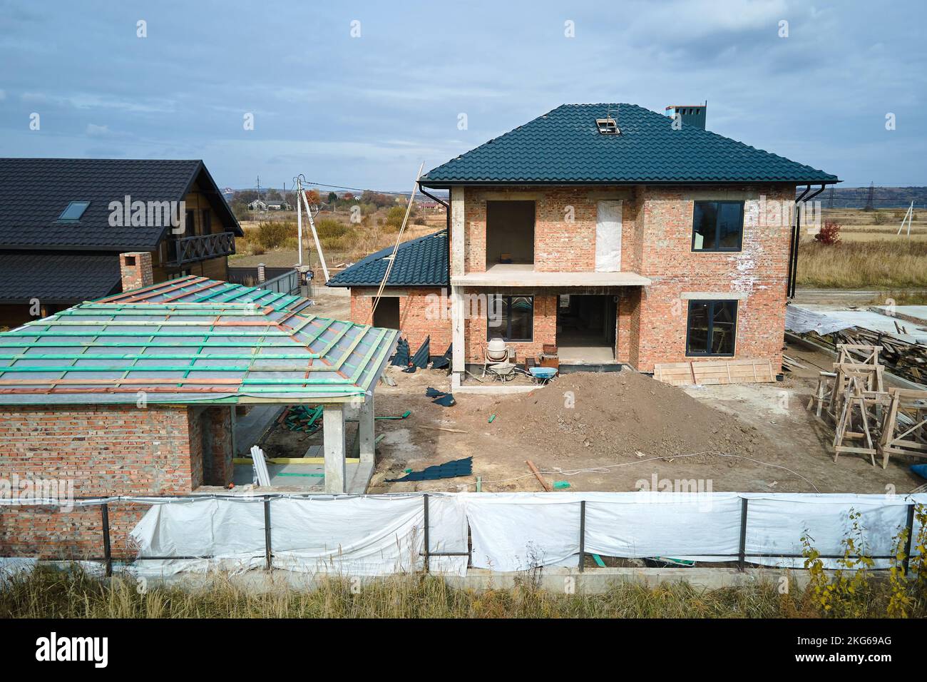 Aerial view of unfinished house with brick walls and wooden roof frame ...