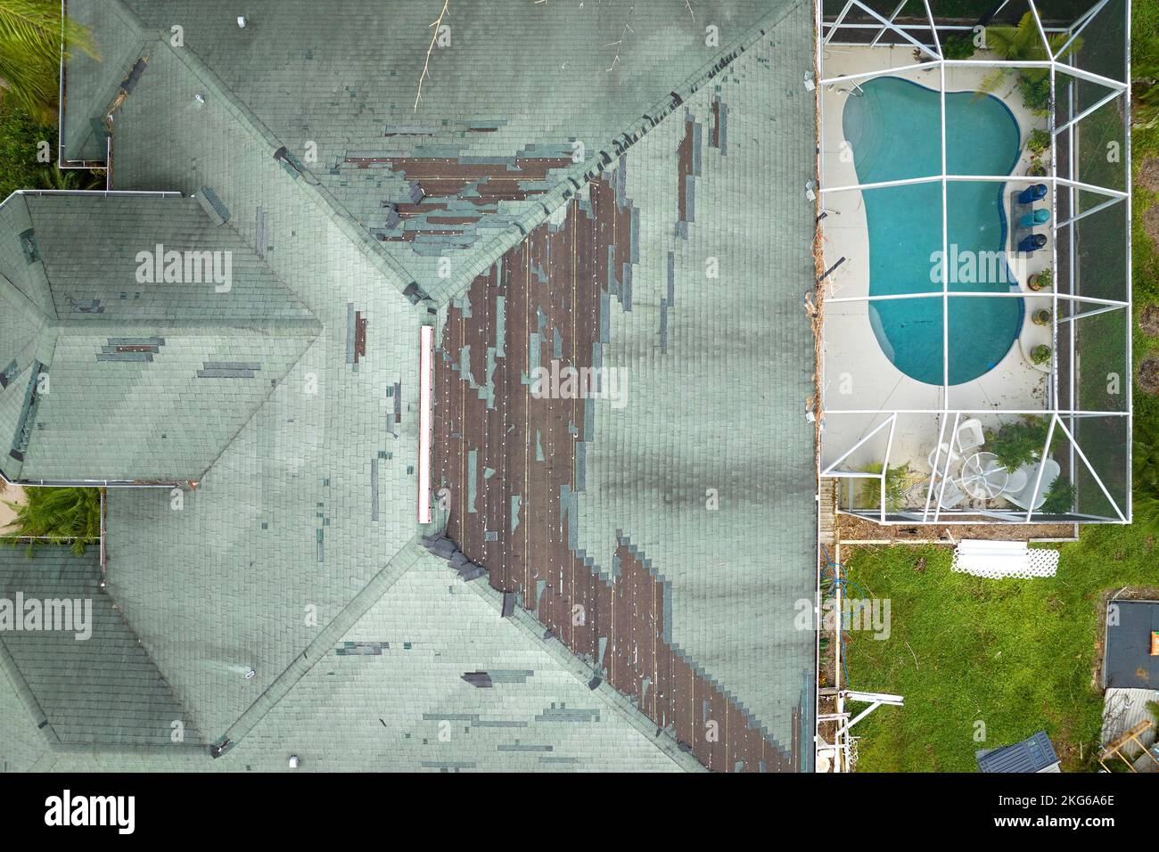 Damaged house roof with missing shingles after hurricane Ian in Florida ...