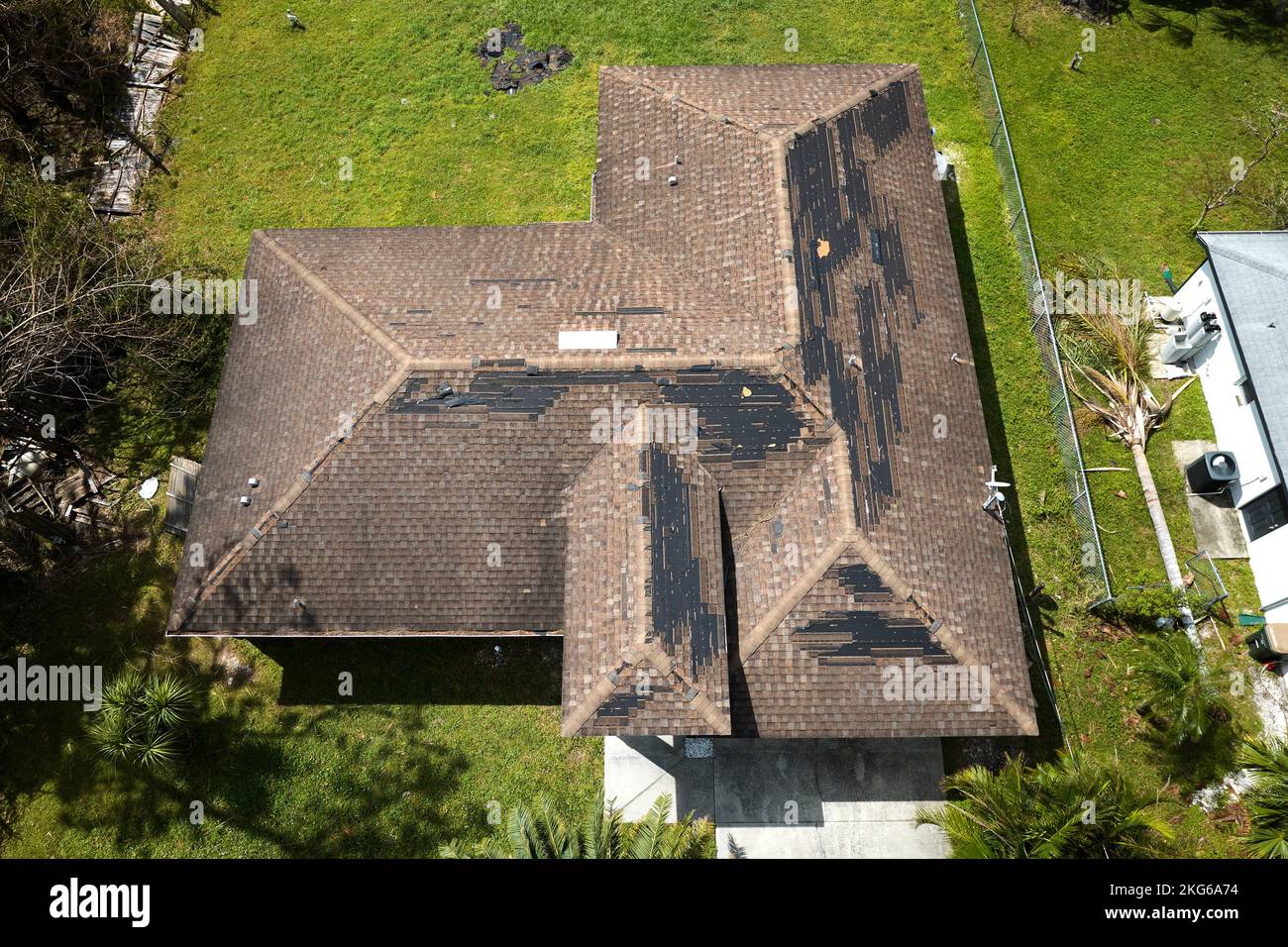 Damaged house roof with missing shingles after hurricane Ian in Florida ...