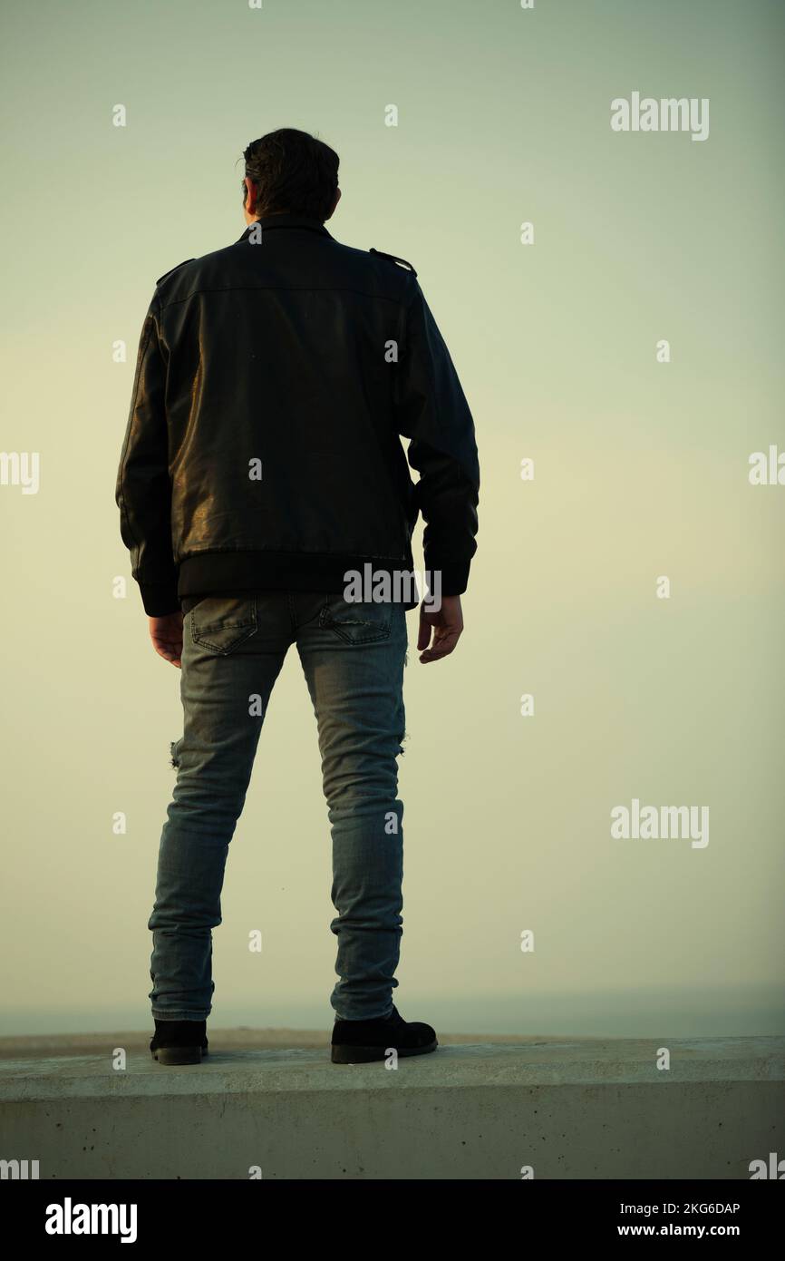 Rear view of man in leather jacket standing outdoors Stock Photo - Alamy