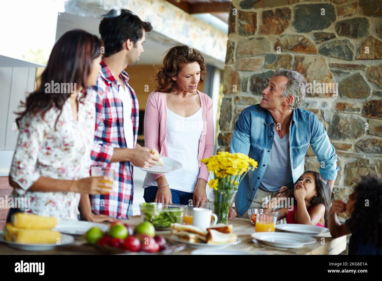 Lets sit down and eat. A happy family enjoying a meal time together ...