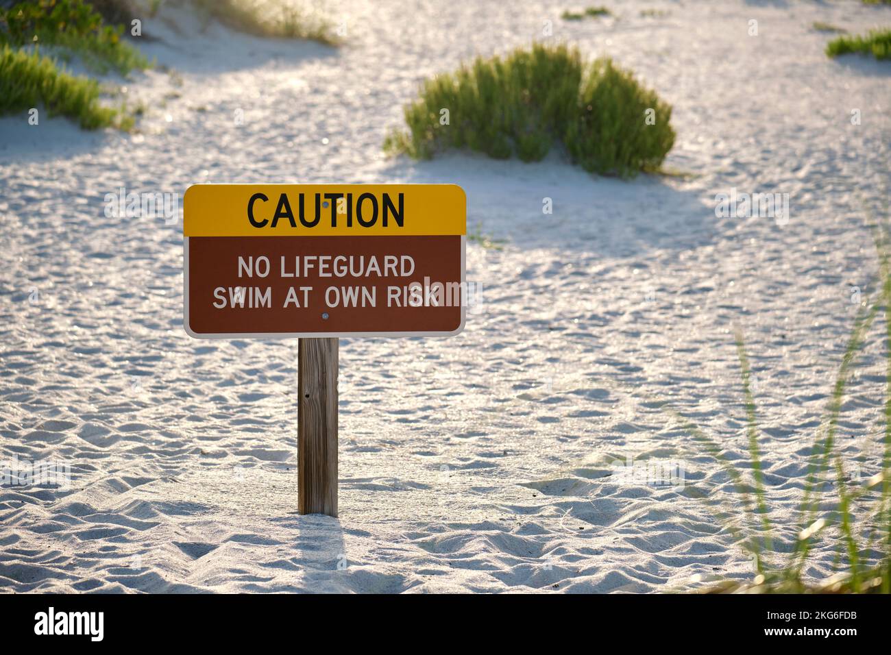 Warning sign poster on sea side beach saying that there is no lifeguard ...