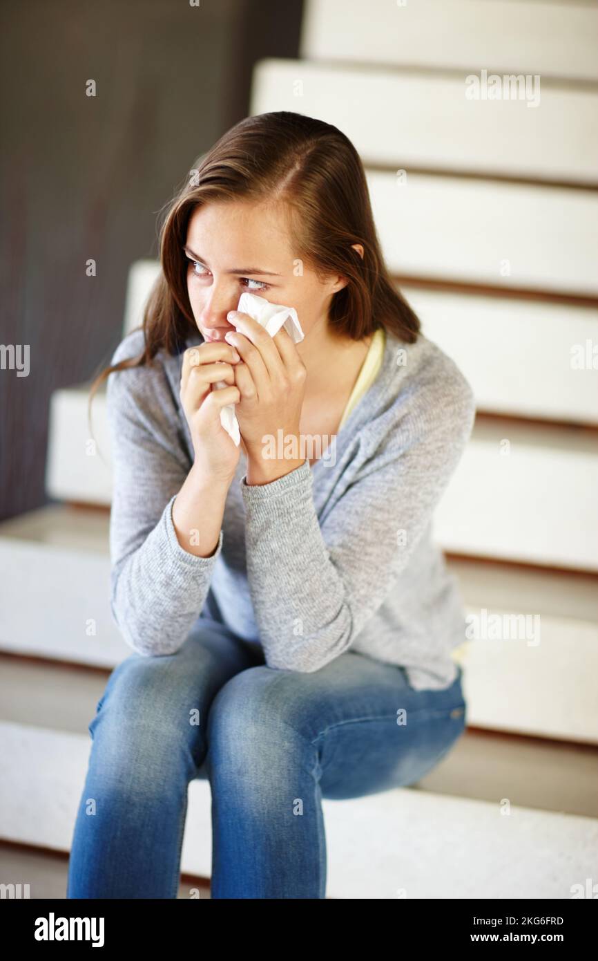 On the road to getting over it. an unhappy young woman crying on a ...