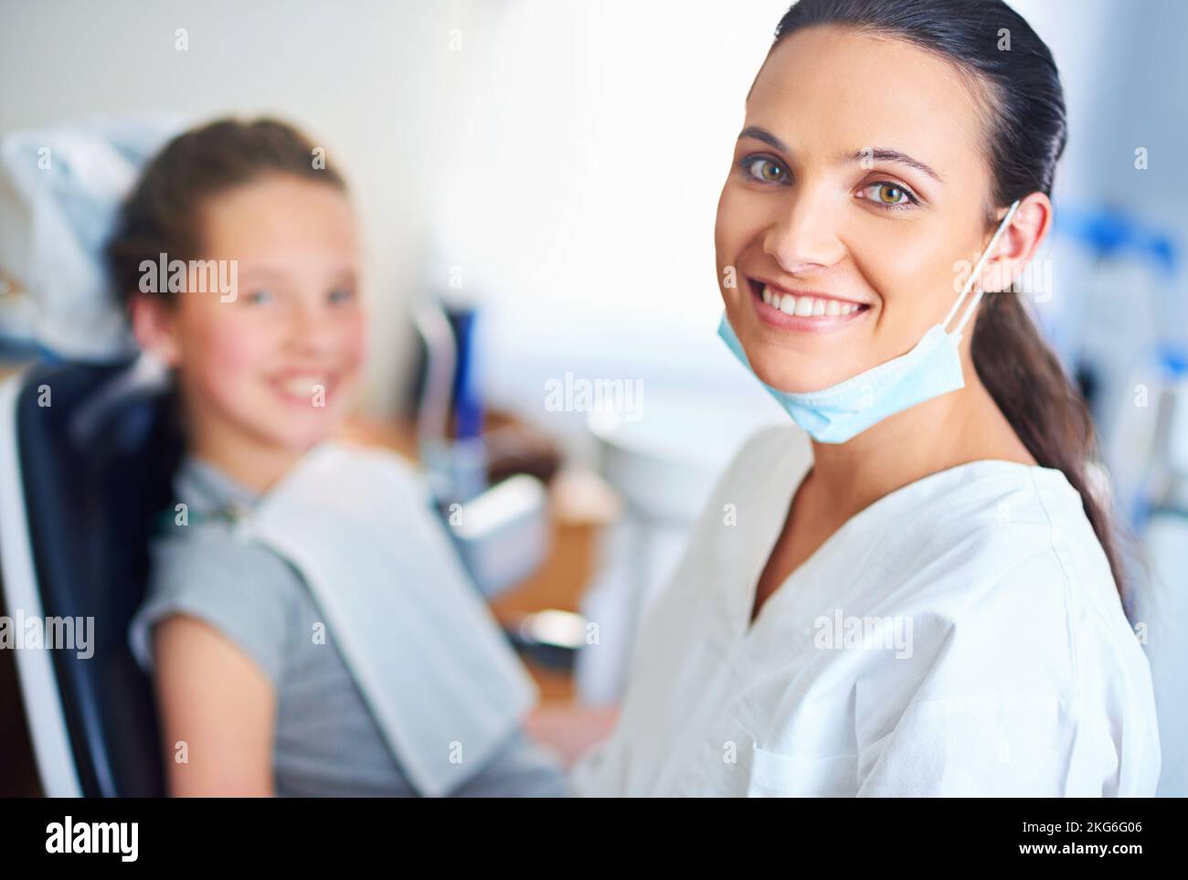 Two perfect smiles. Portrait of a female dentist and child in a dentist ...