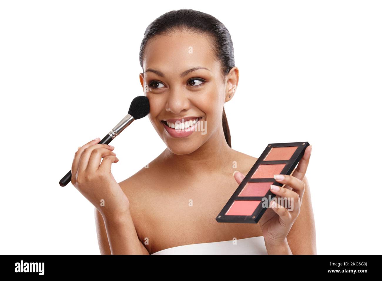 Wake up and makeup. a beautiful young woman applying blush to her face ...