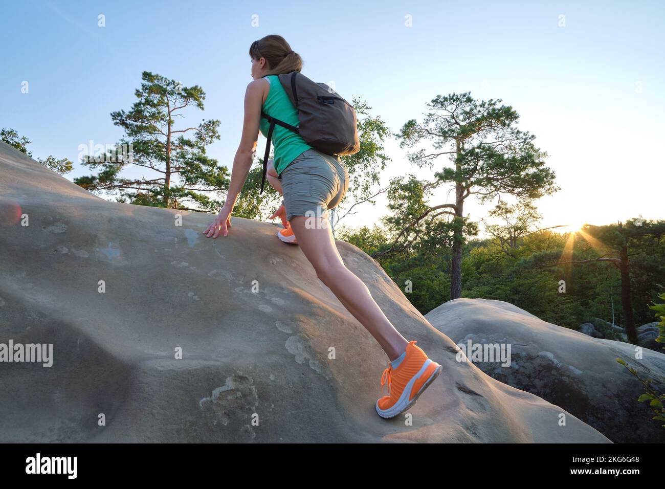 Young woman climbing alone on rocky mountain path. Female hiker ...