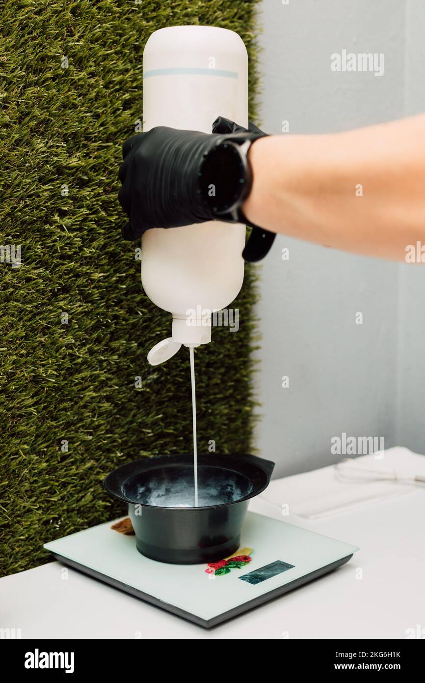 A hairdresser pours an oxidizer. The process of preparation before ...