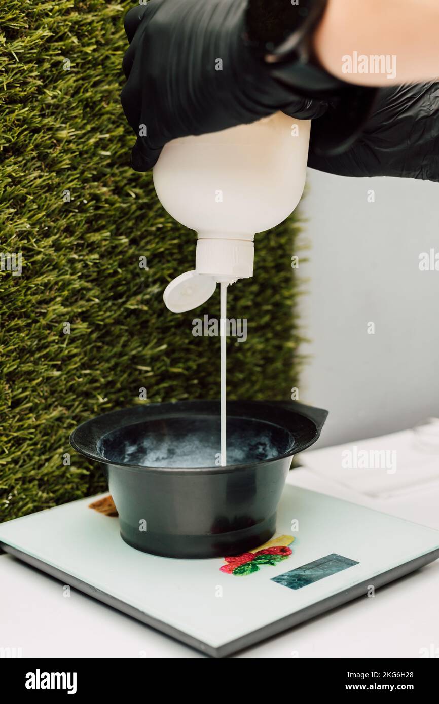 A hairdresser pours an oxidizer. The process of preparation before ...