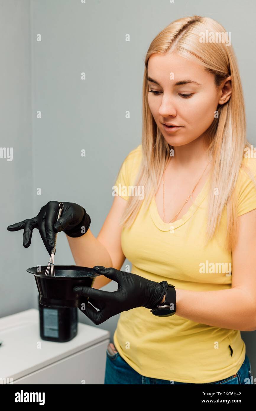 A professional hairdresser mixes a dye with an oxidizer. Hair coloring ...