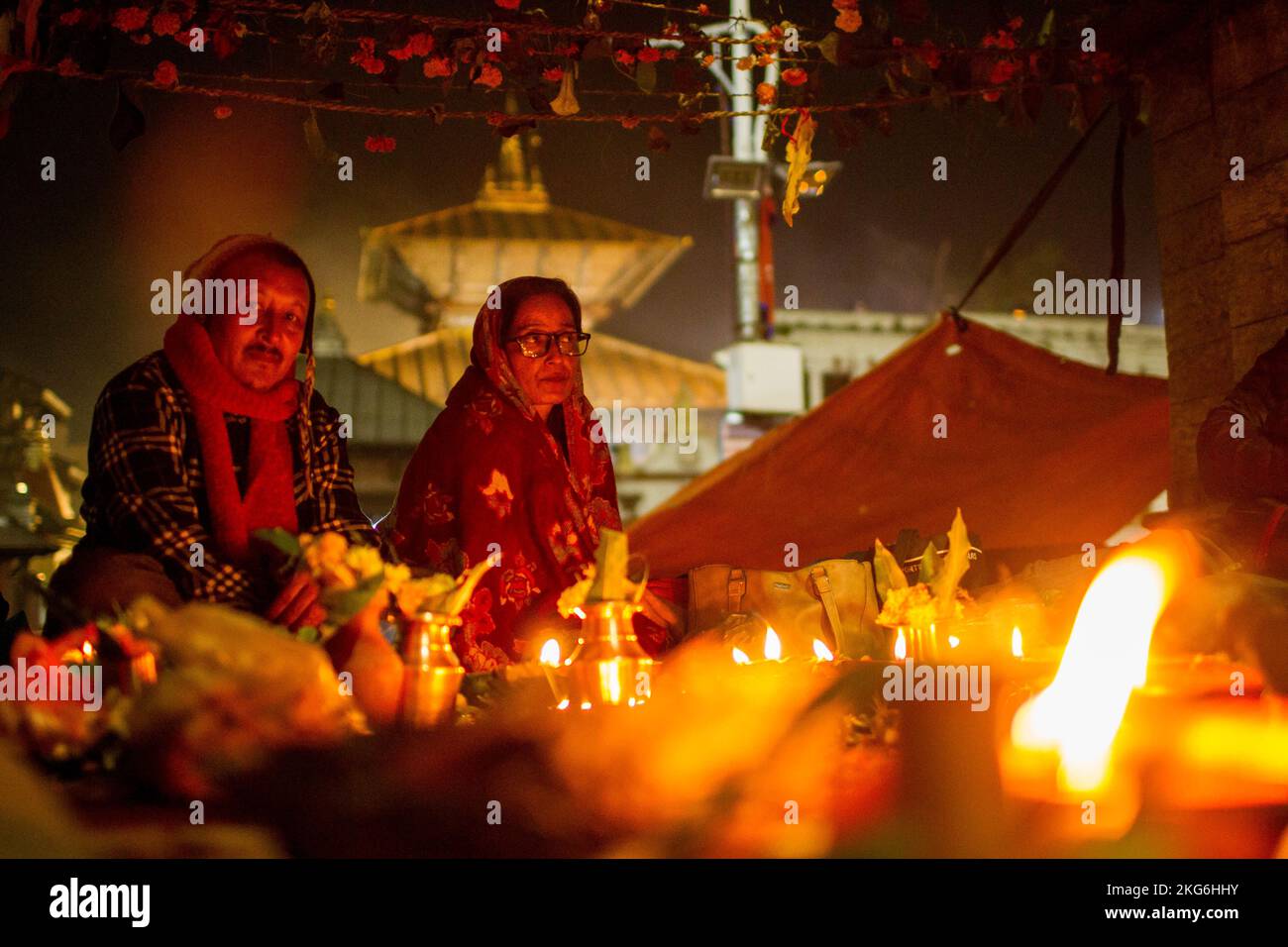 Kathmandu, Nepal. 21st Nov, 2022. People sit beside oil lamps during ...