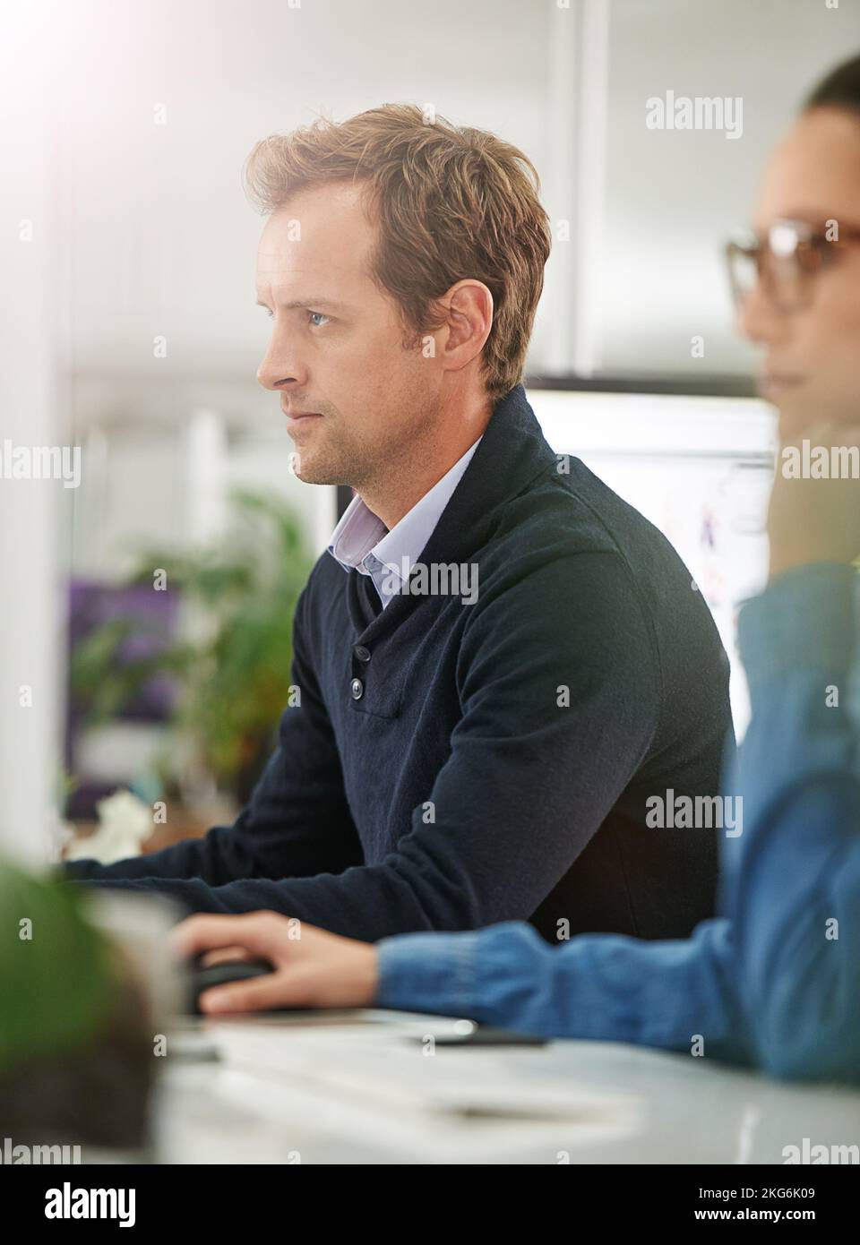 Focused on the task at hand. two colleagues at their desks Stock Photo ...