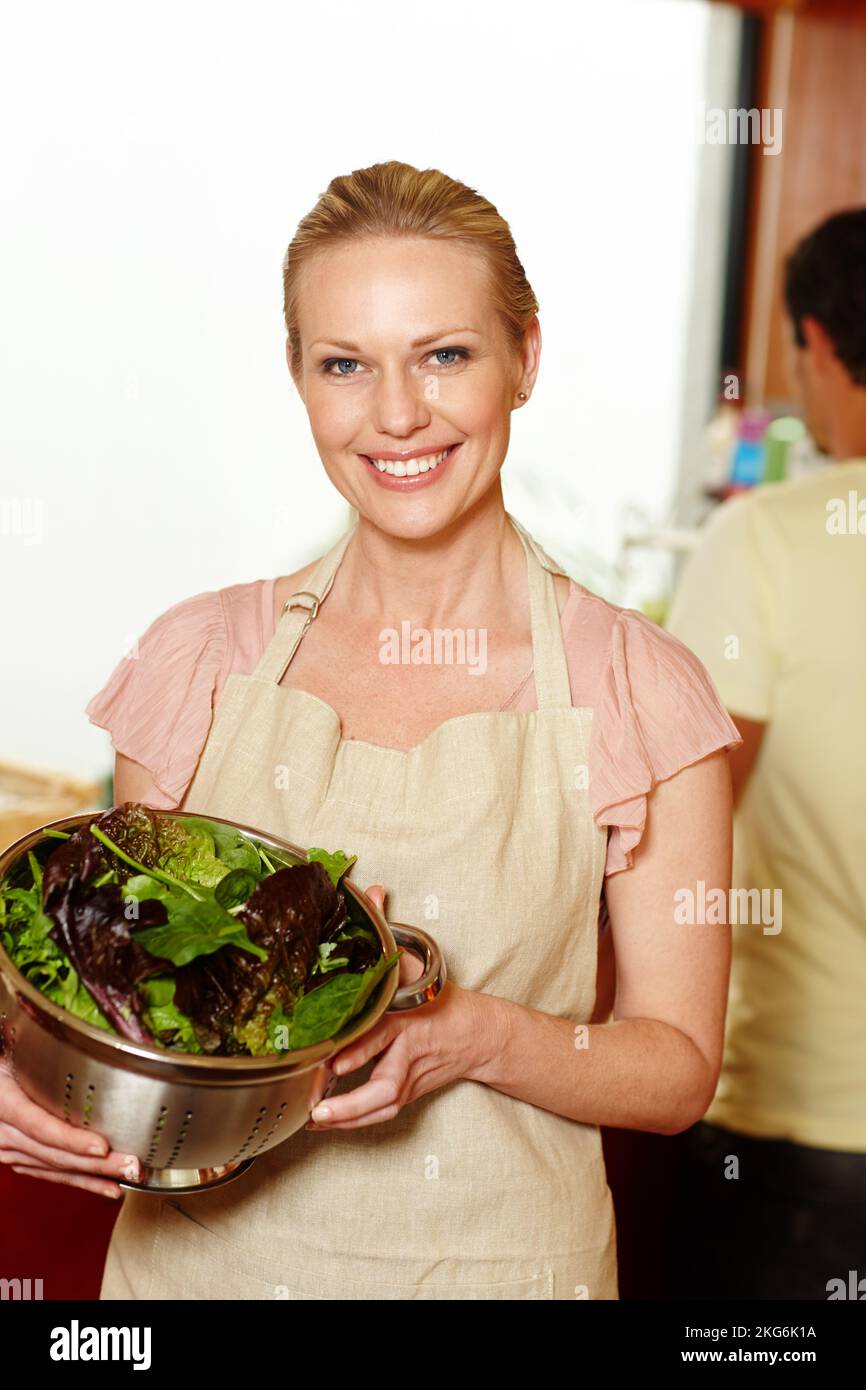 Preparing a healthy lunch. A beautiful woman standing in her kitchen ...