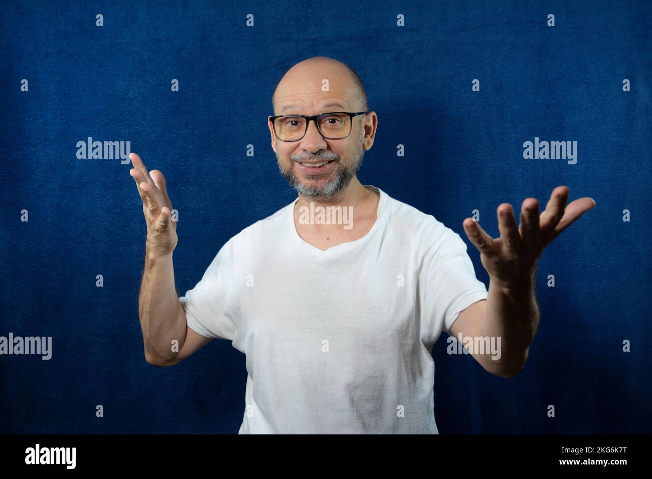 The portrait of a bearded bald man imitating something with his hands ...