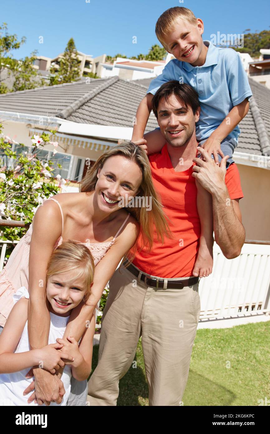The place they call home. Portrait of a loving family of four standing ...