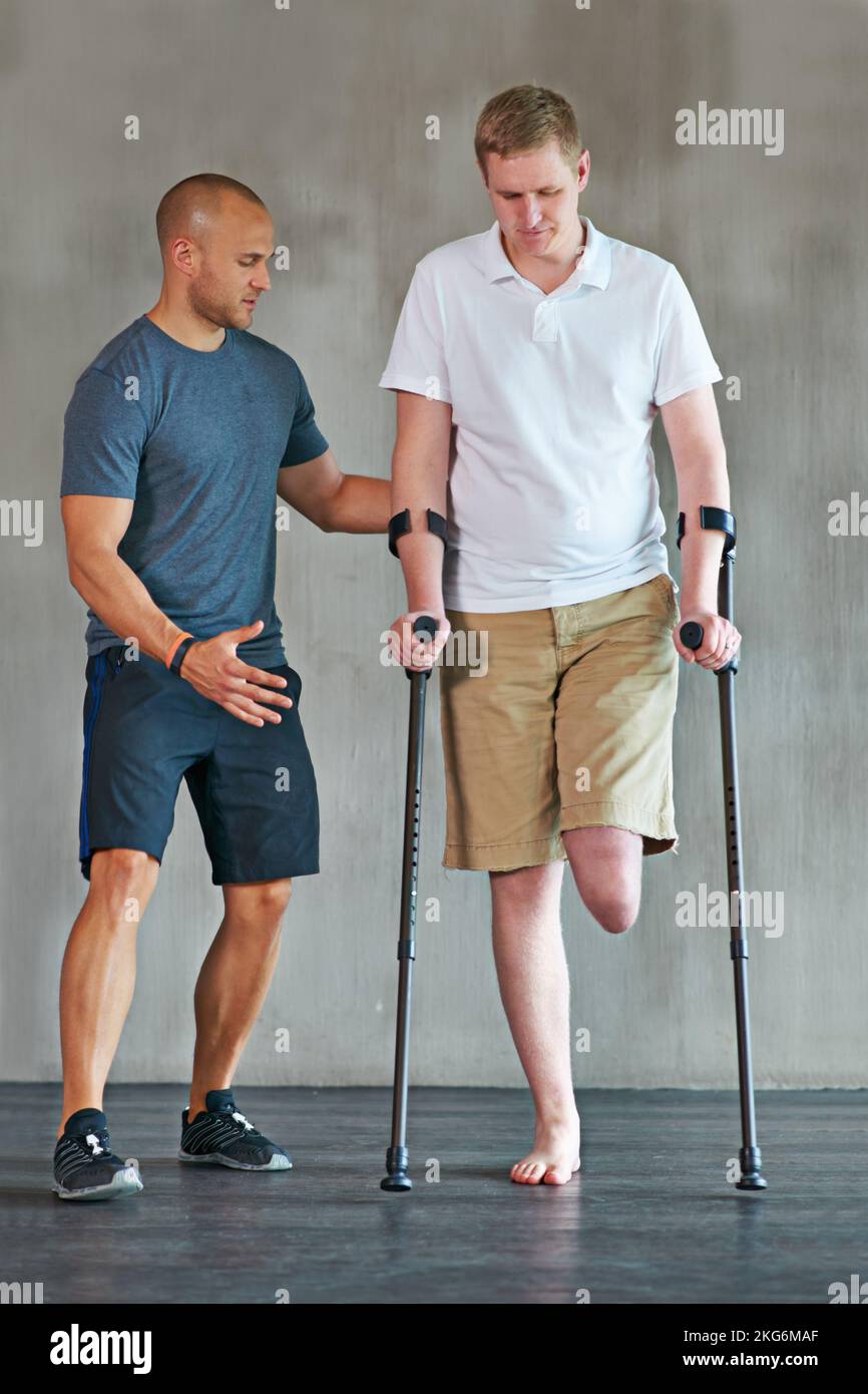 Learning how to walk after amputation. Studio shot of a young amputee ...