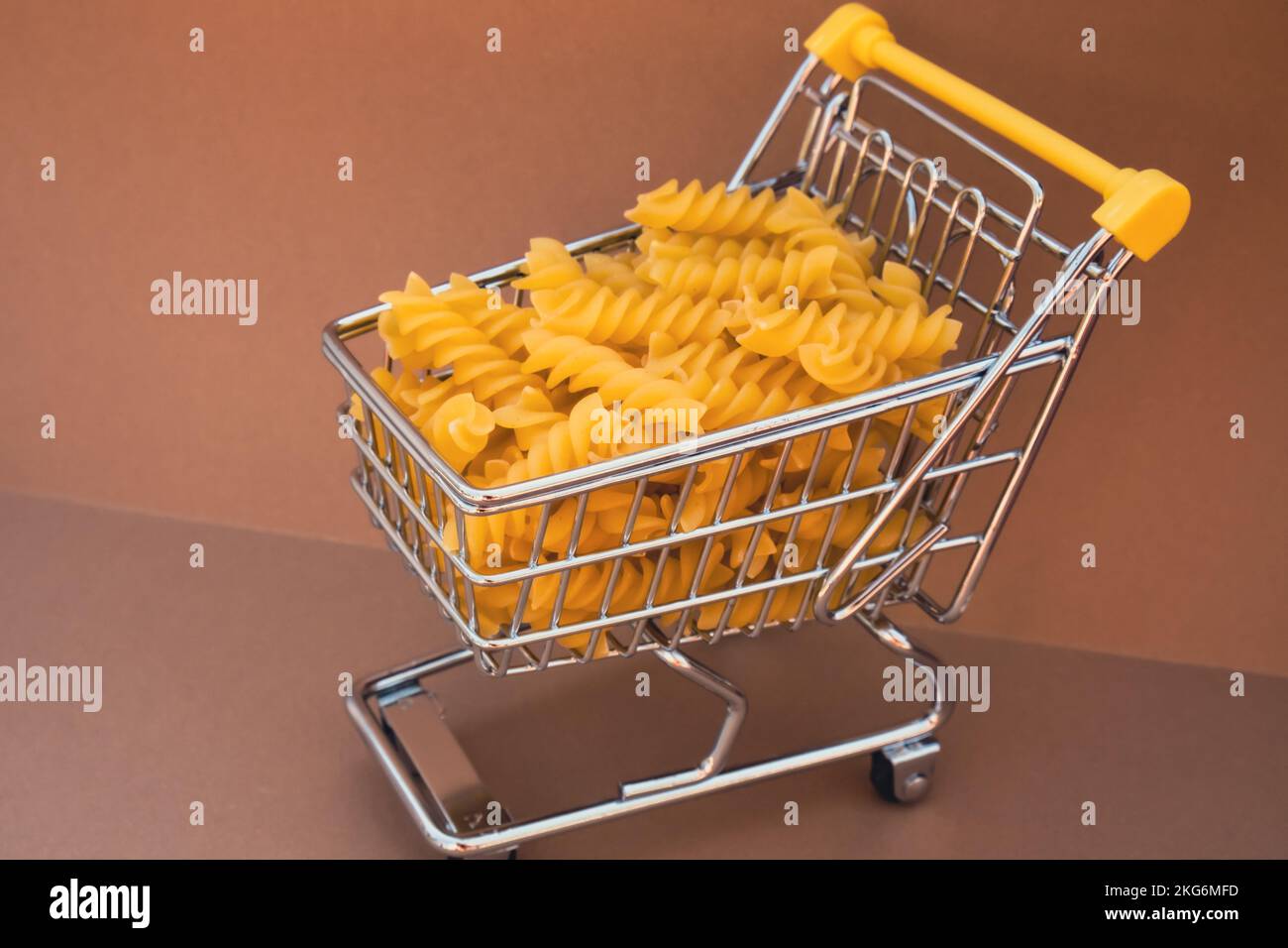 Shopping trolley cart Filled With Pasta on Beige background. Copy space ...